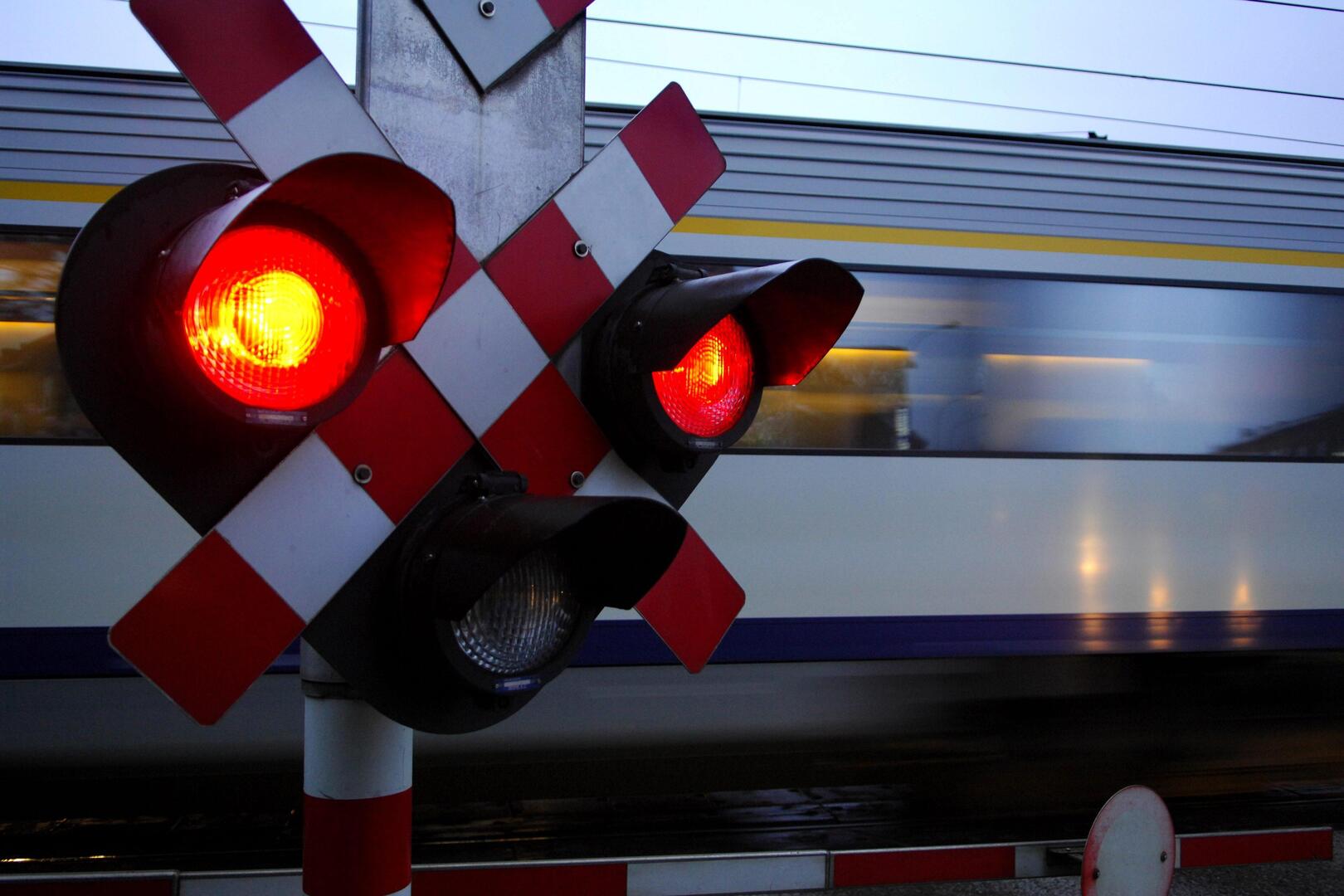 Jonge vrouw negeert rode lichten en kruist trein op gesloten overweg ...